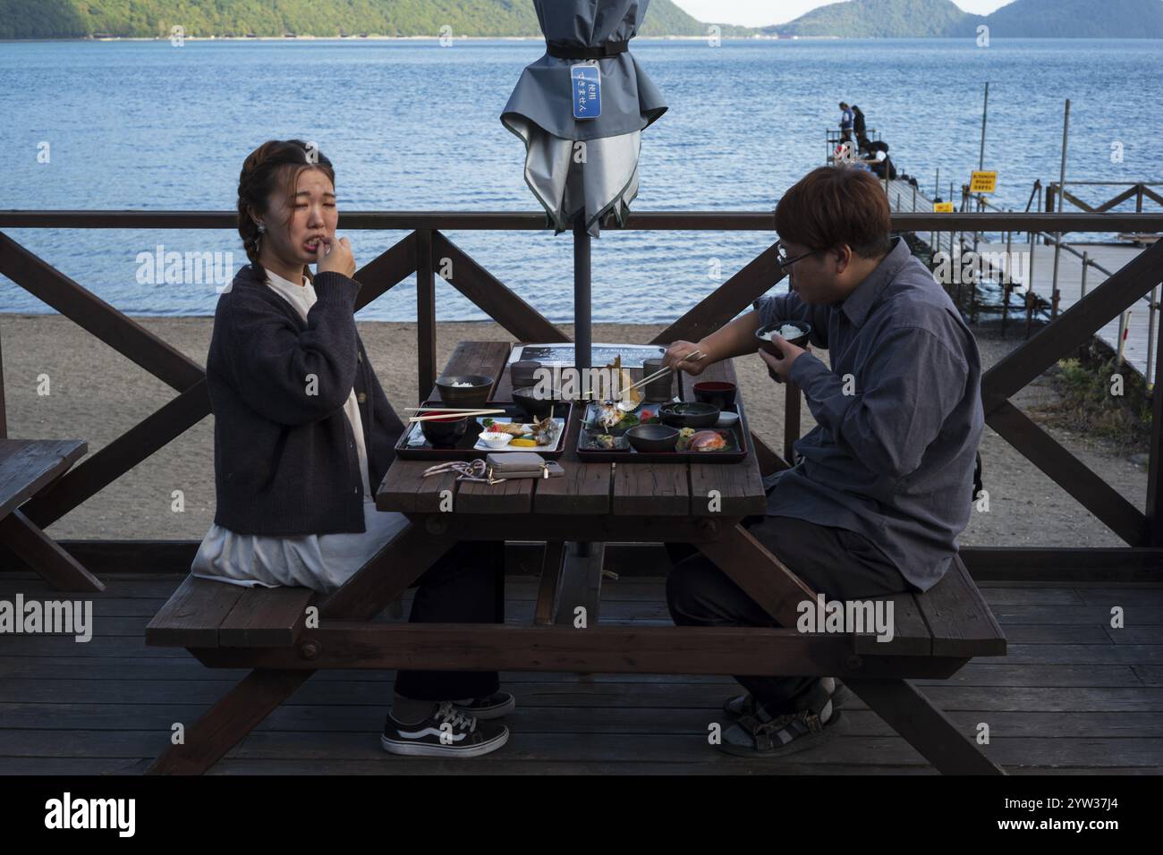 Couple eating grilled fish, Shikotsu-TOya National Park, Lake Shikotsu ...