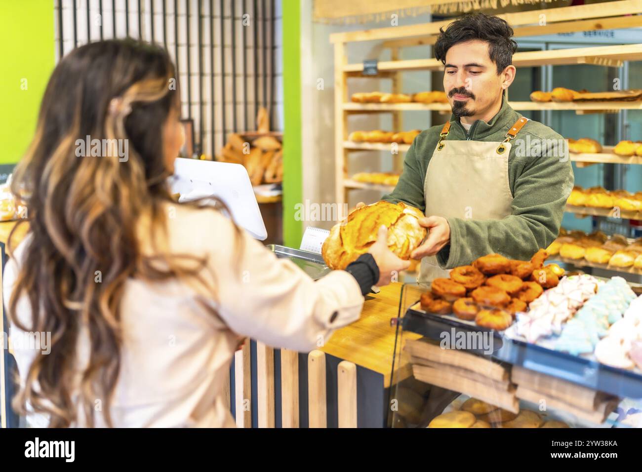 Rear view of an unrecognizable woman buying artisan bread in a modern ...