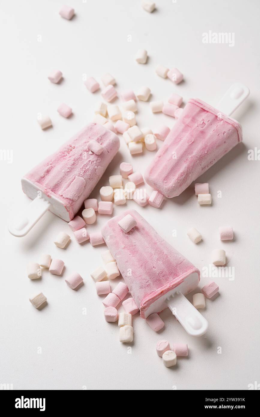 Pink ice cream popsicles arranged with marshmallow toppings ...