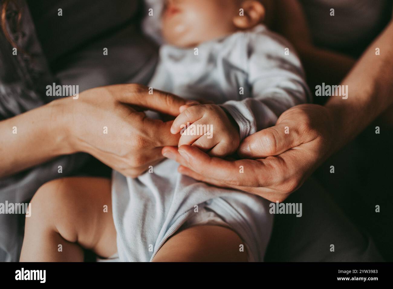 Hands parents touching babys tiny hi-res stock photography and images ...
