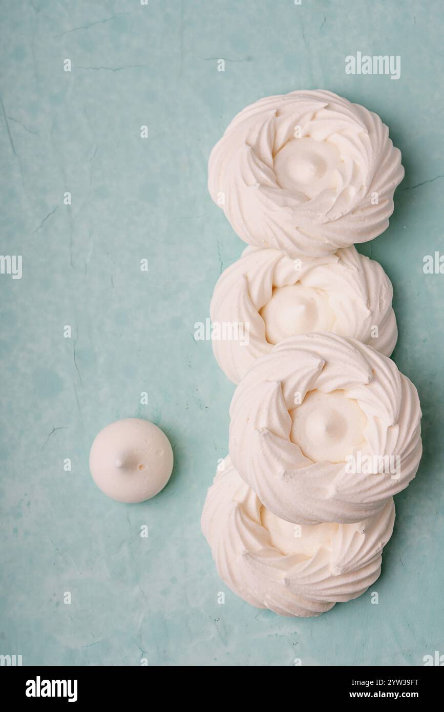 Artistic arrangement of delicate meringue nests on a pastel aqua ...