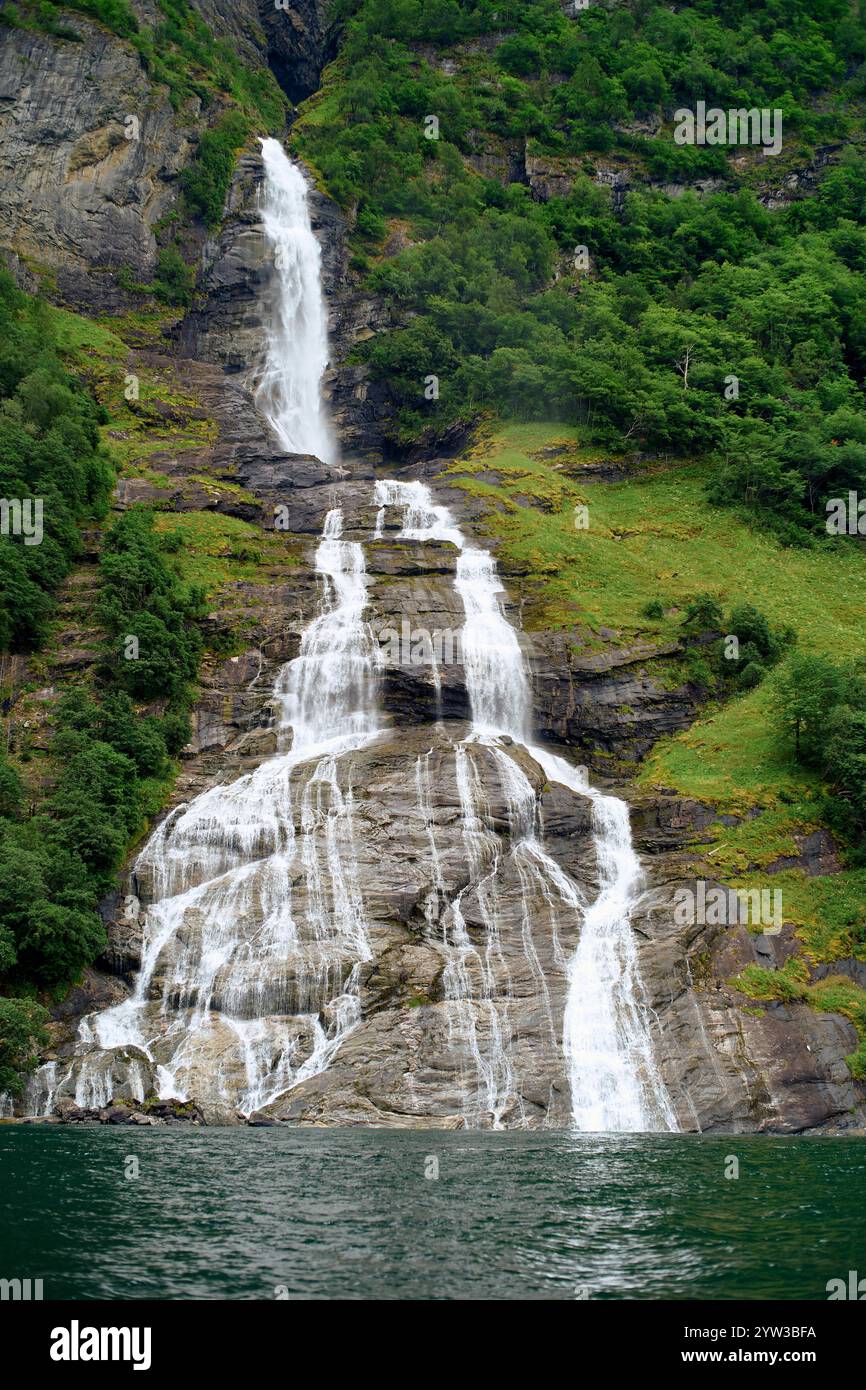 A scenic waterfall cascading down a lush green cliffside ...