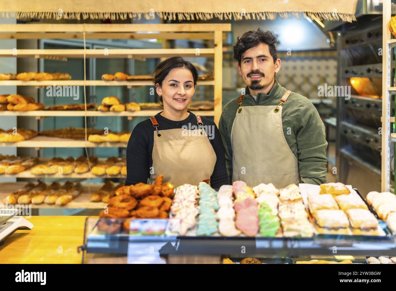 Portrait of a couple of latin young artisans bakery shop owners Stock ...