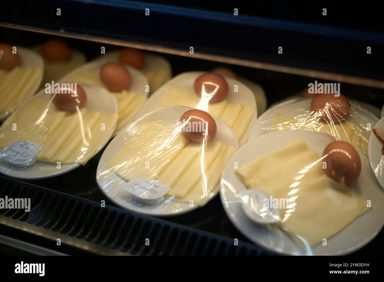 Individually wrapped breakfast with slices of cheese topped with eggs ...