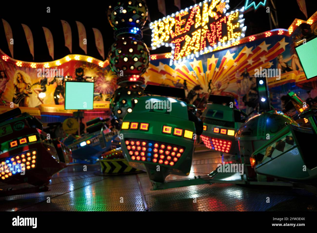 Colorful amusement park ride at night with bright lights and motion ...