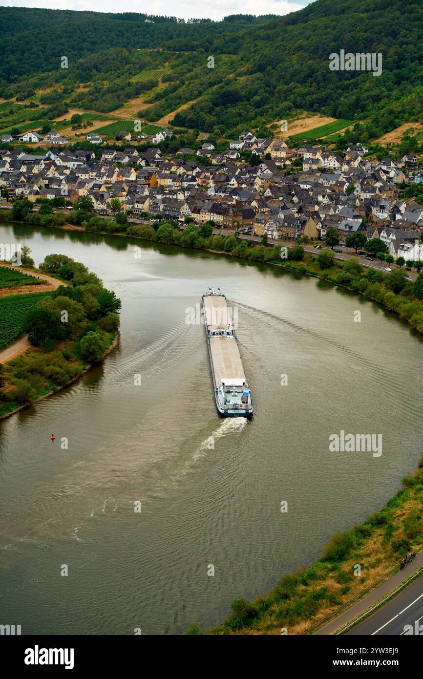 Aerial view of a cargo ship on a river bending around a quaint European ...