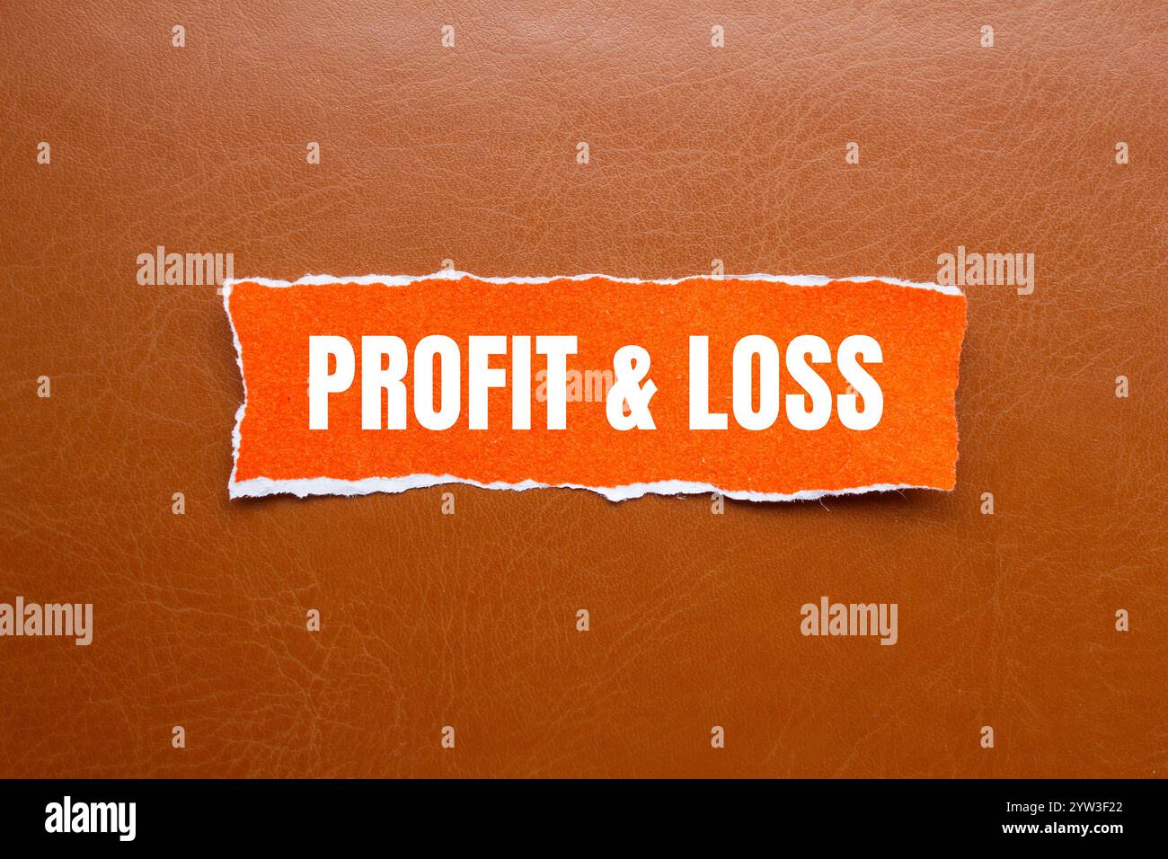 Profit and loss message written on ripped orange torn paper piece with ...