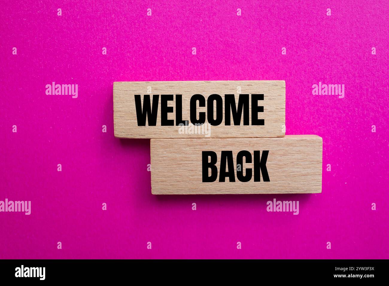 Welcome back message written on wooden blocks with pink background ...