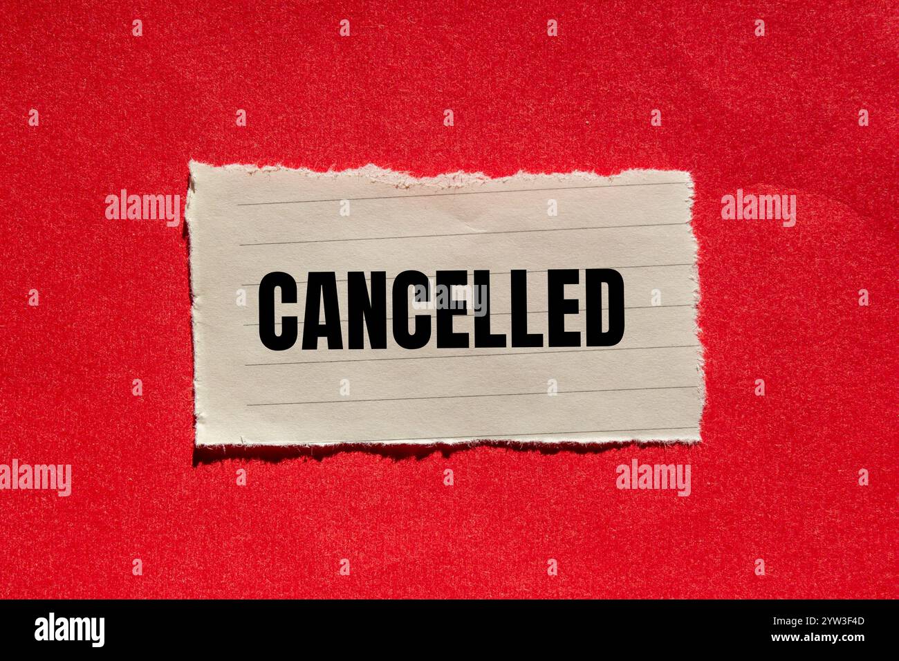 Cancelled message written on ripped torn paper piece with red background. Conceptual cancelled ...