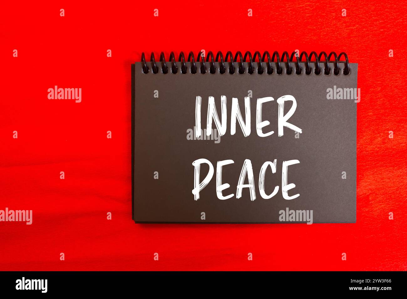 Inner peace message written on black notebook page with red background ...
