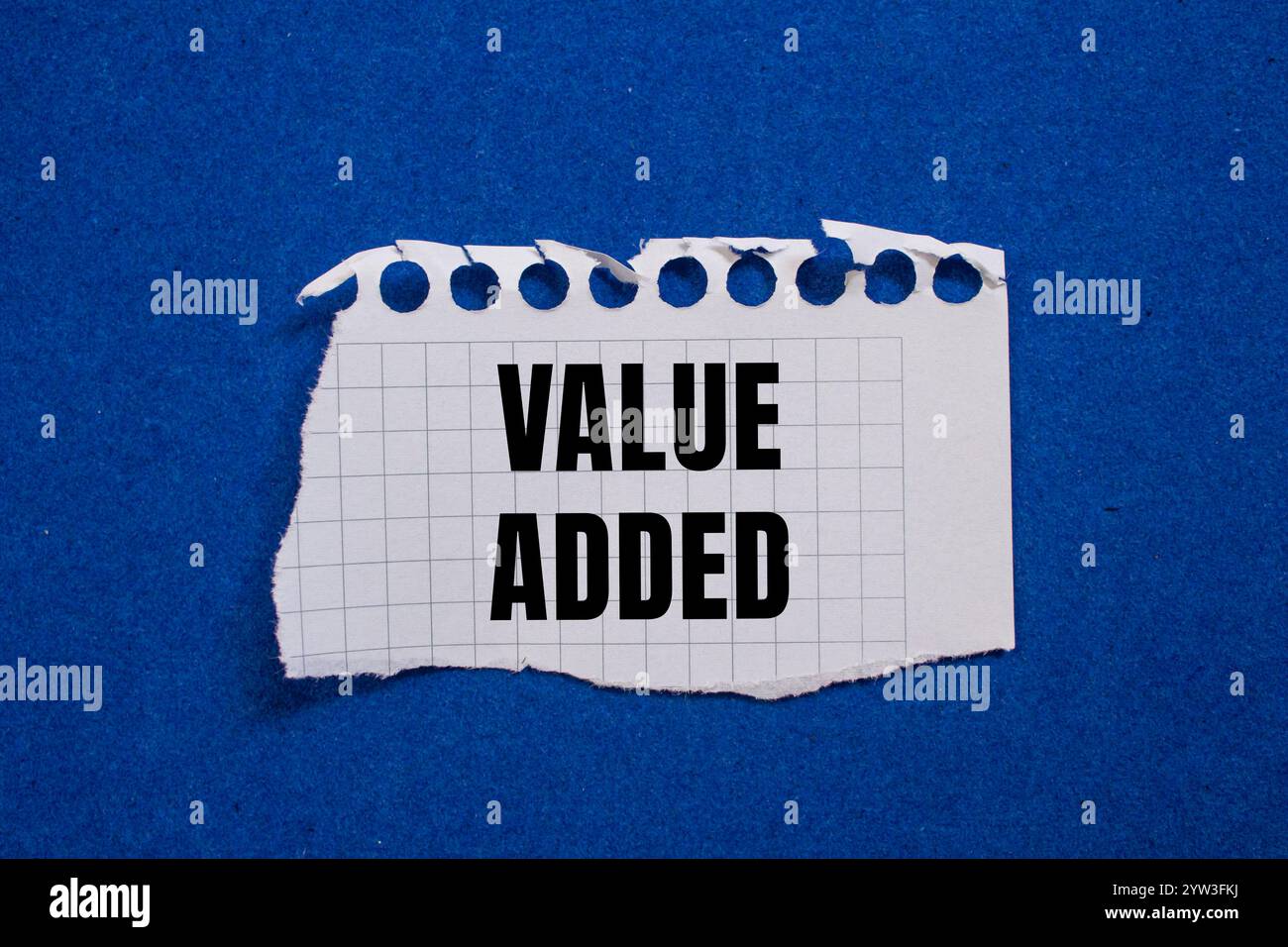 Value added message written on ripped torn paper piece with blue ...