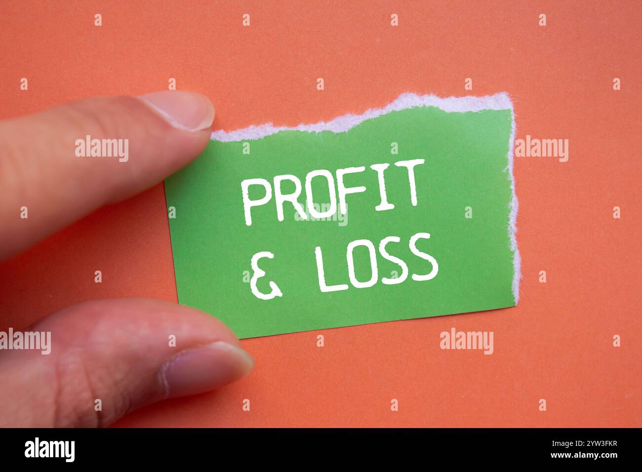 Profit and loss message written on ripped green torn paper with orange ...
