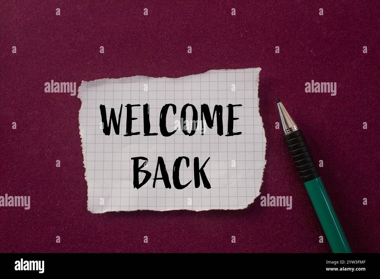 Welcome back message written on ripped torn paper piece with purple ...