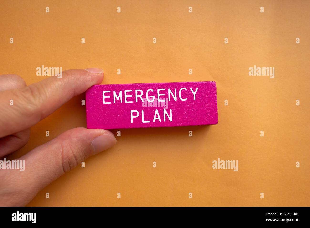Emergency plan message written on pink wooden block with orange ...