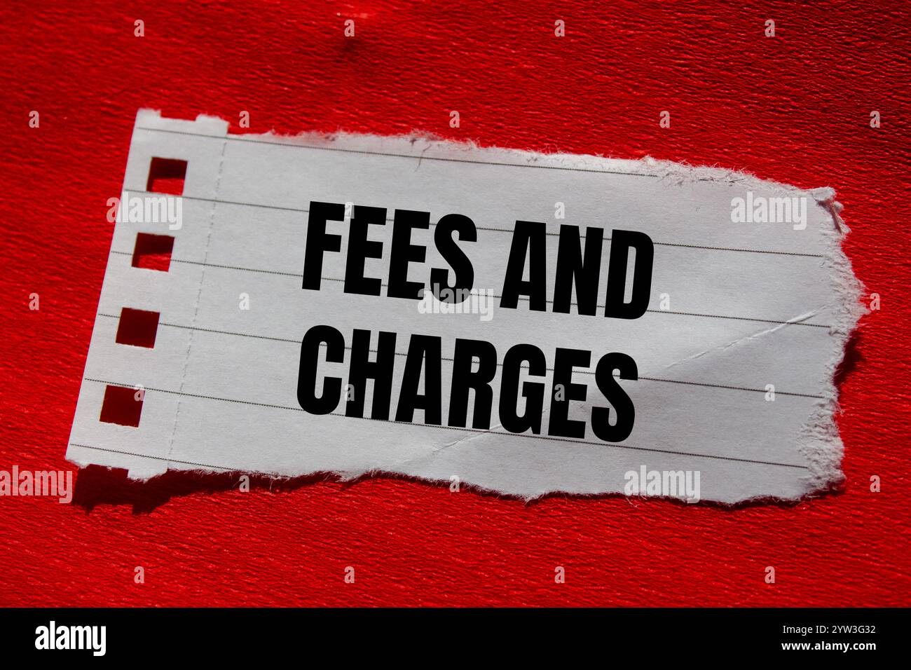 Fees and charges message written on ripped torn paper piece with red ...