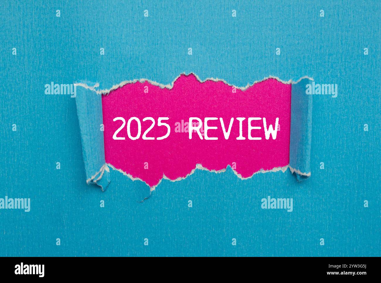 2025 review message written on ripped torn blue paper with pink background. Conceptual 2025 ...