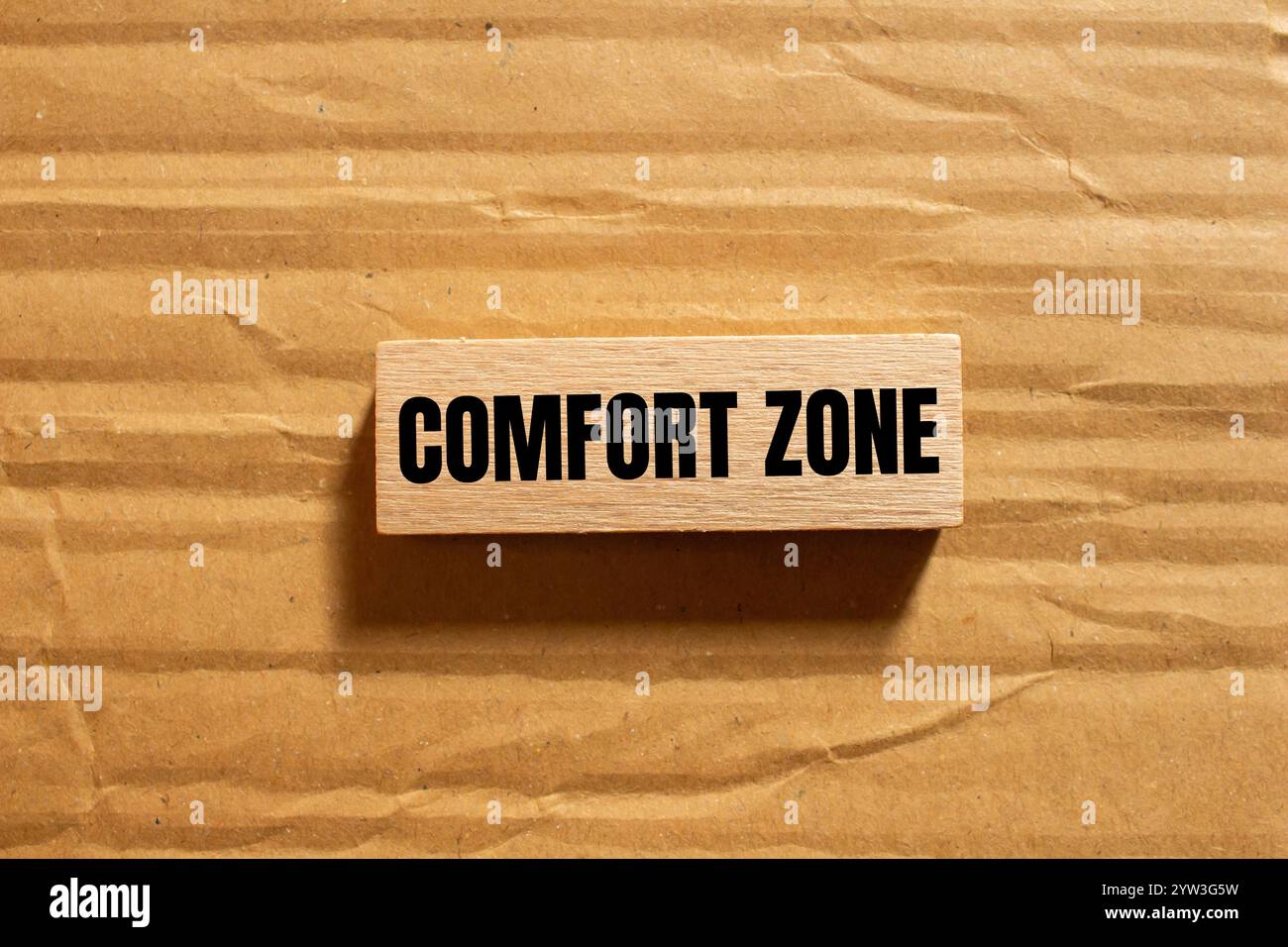 Comfort zone message written on wooden block with cardboard background ...