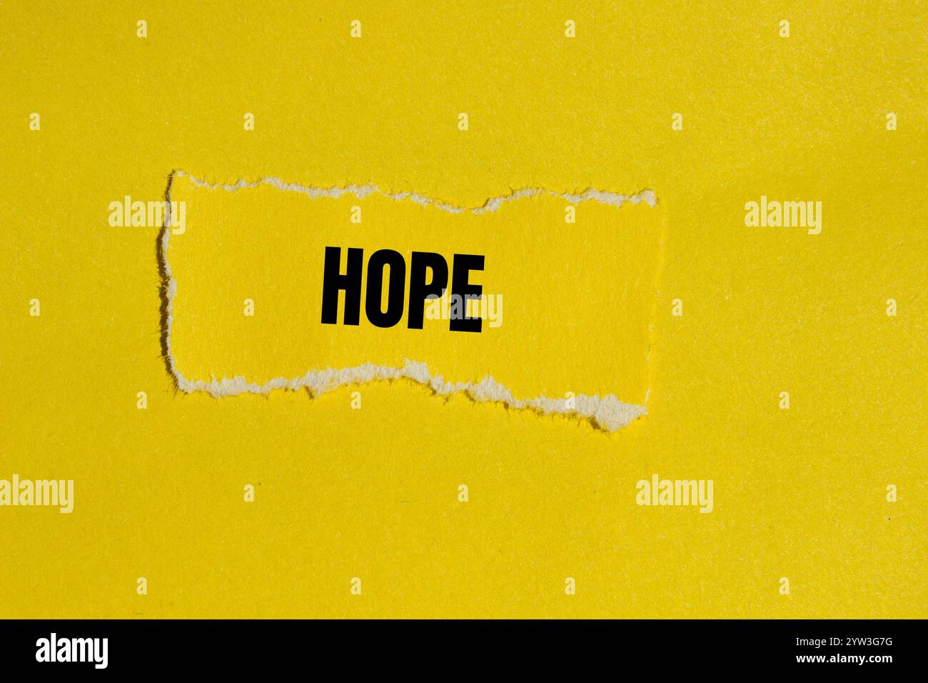 Hope message written on ripped yellow torn paper piece with yellow background. Conceptual hope ...