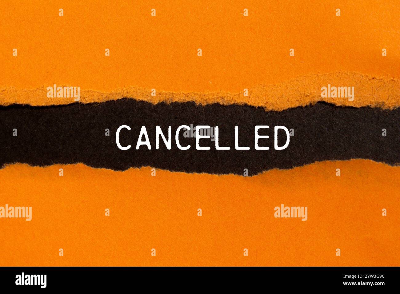 Cancelled message written on ripped torn orange paper with black background. Conceptual ...