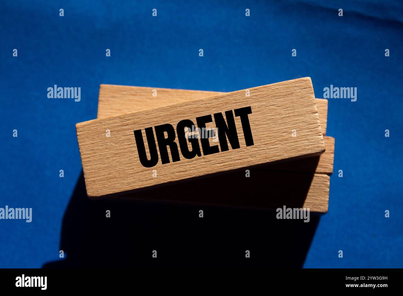 Urgent message written on wooden blocks with blue background ...
