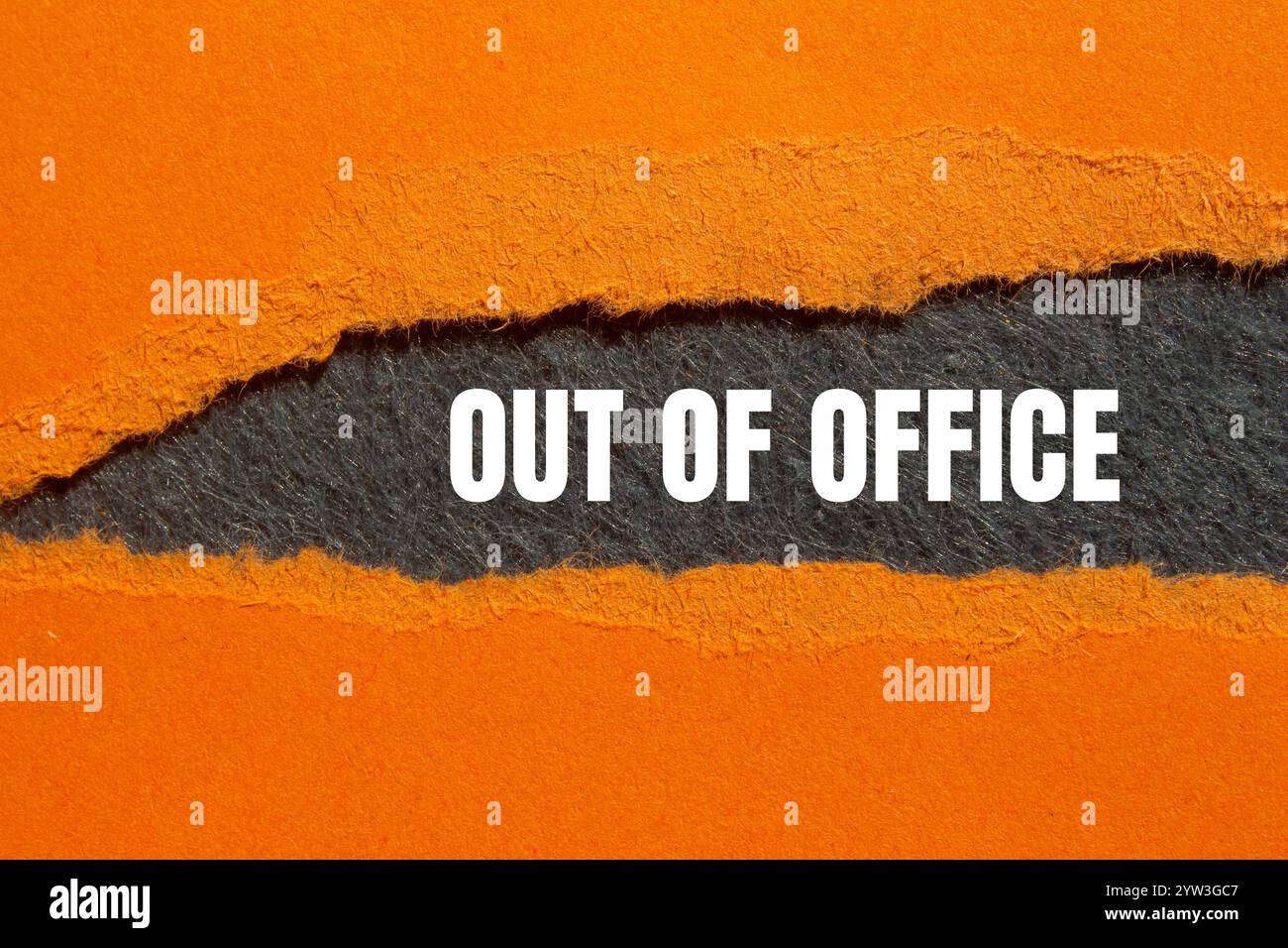 Out of office message written on ripped torn orange paper with gray background. Conceptual out ...