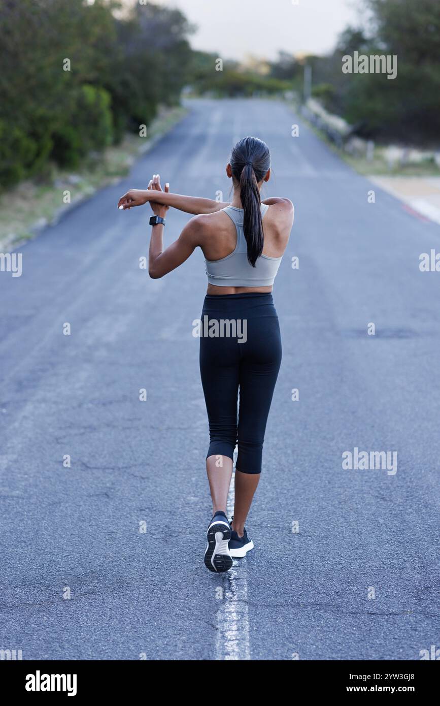 Full length of slim athlete walking on an abandoned road and warming up ...