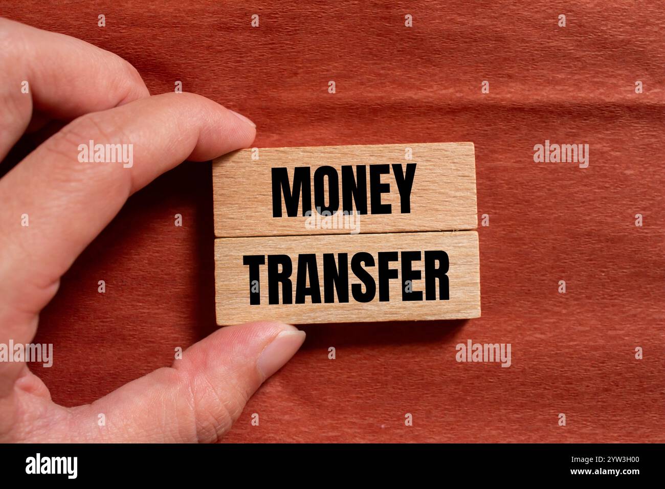 Money transfer message written on wooden blocks with brown background ...