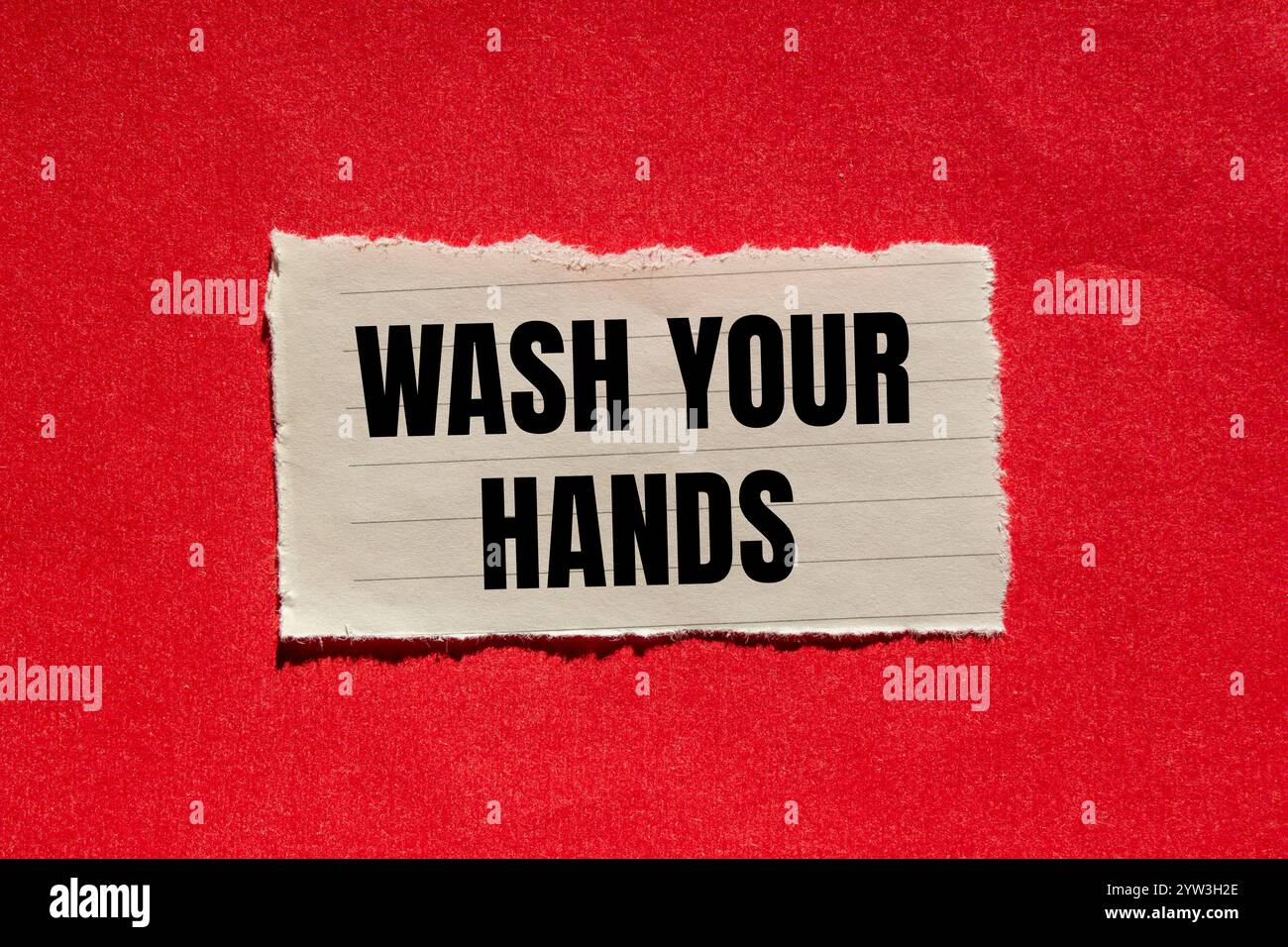 Wash your hands message written on ripped torn paper piece with red background. Conceptual wash ...