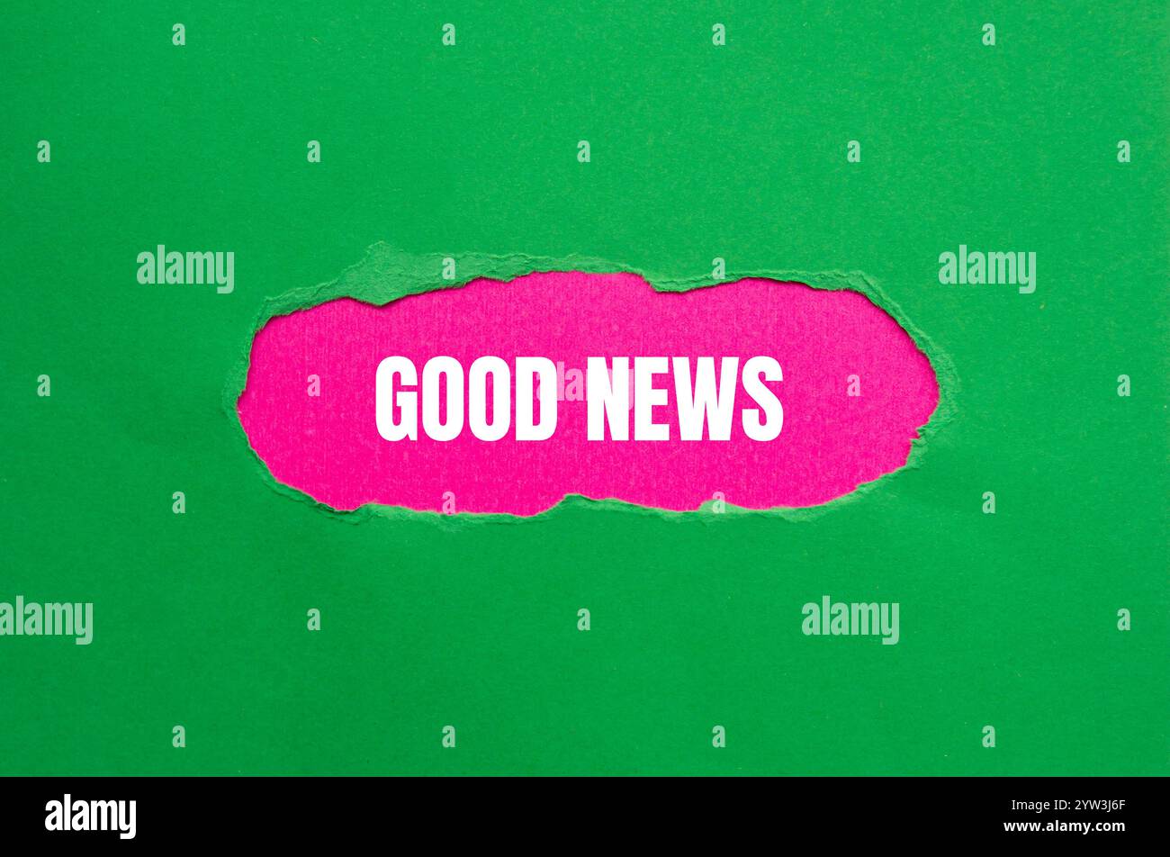 Good news message written on ripped torn green paper with pink ...