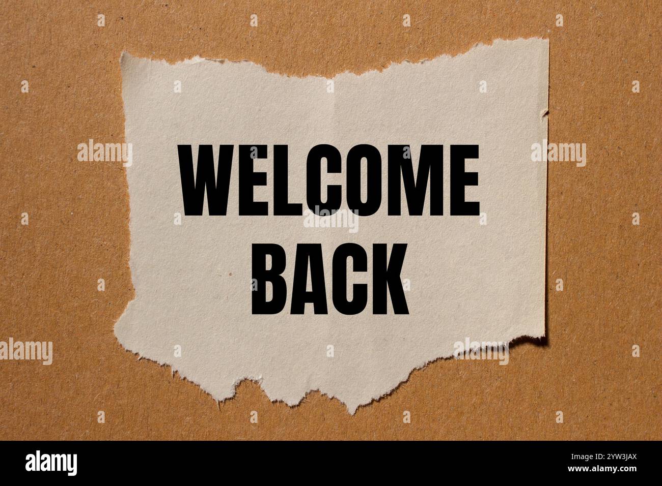 Welcome back message written on ripped torn paper piece with brown ...