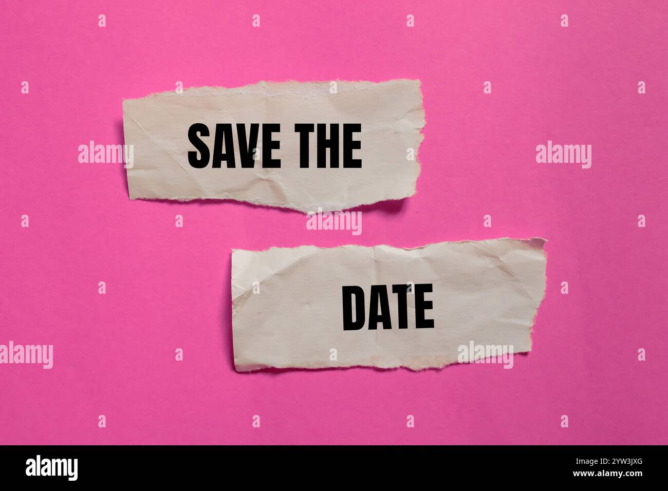 Save the date message written on ripped paper pieces with pink ...