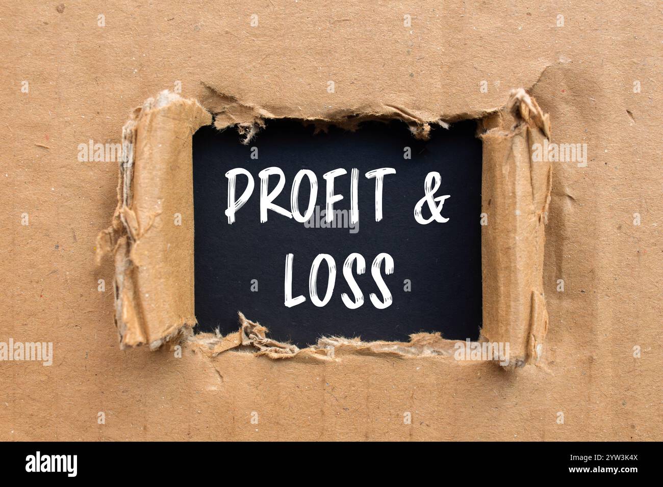Profit and loss message written on ripped torn cardboard paper with black background. Conceptual ...