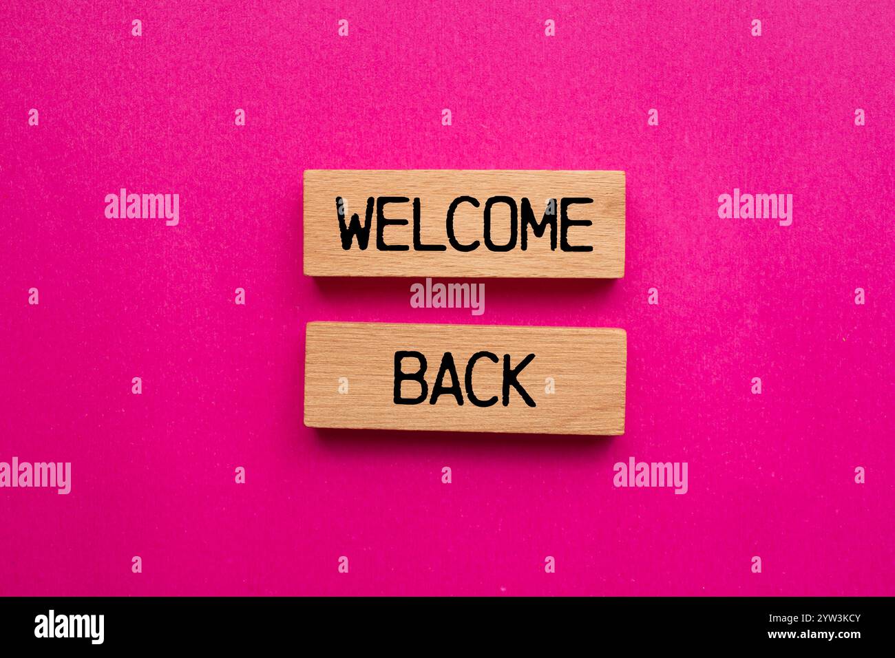 Welcome back message written on wooden blocks with pink background ...