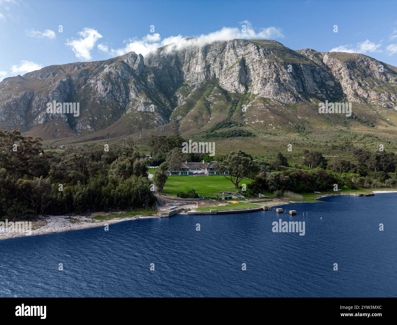 Bay coast landscape, bright green lawn, hotel territory, blue water ...