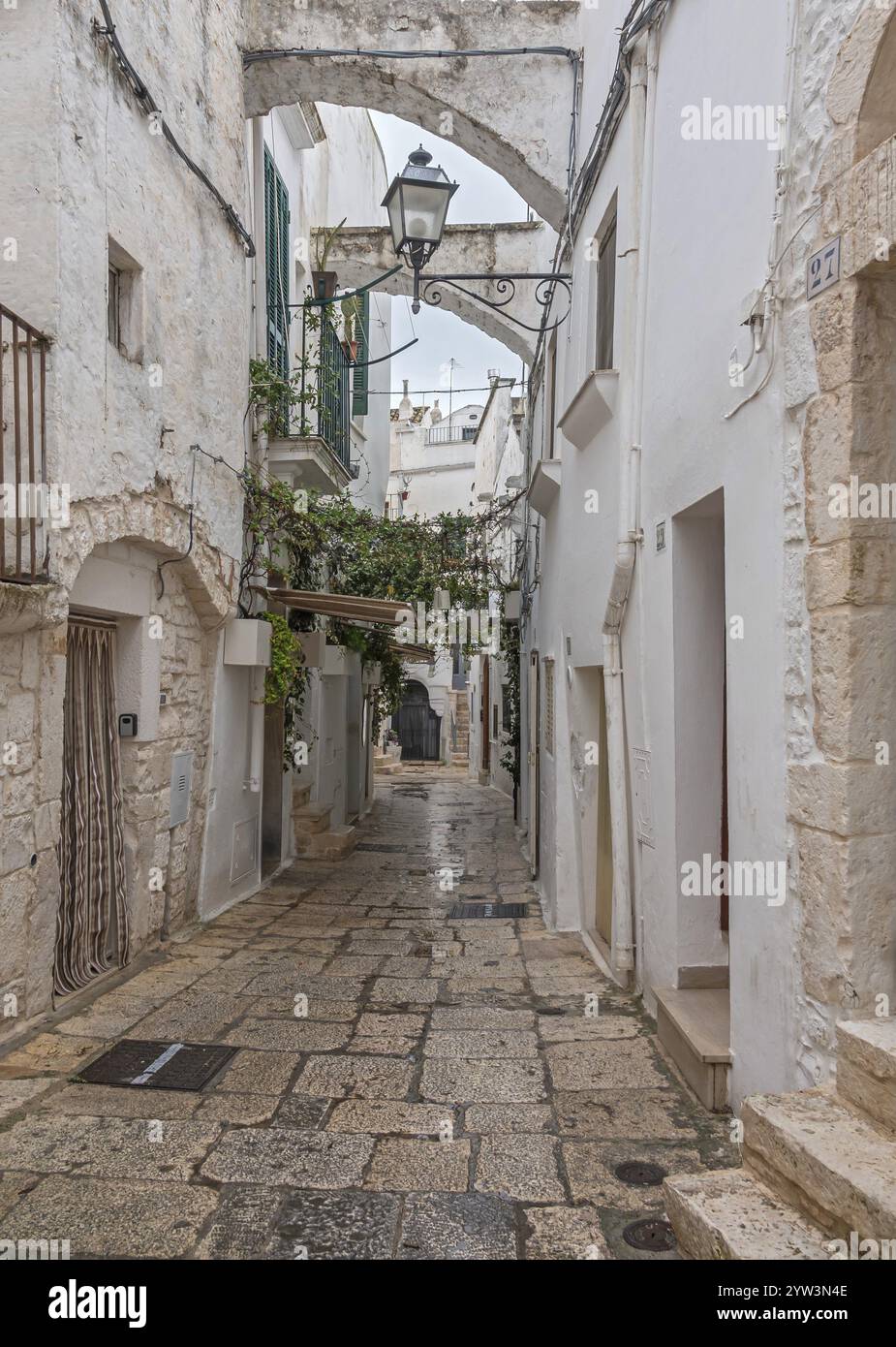 Narrow alley with historic stone buildings and quiet Mediterranean ...