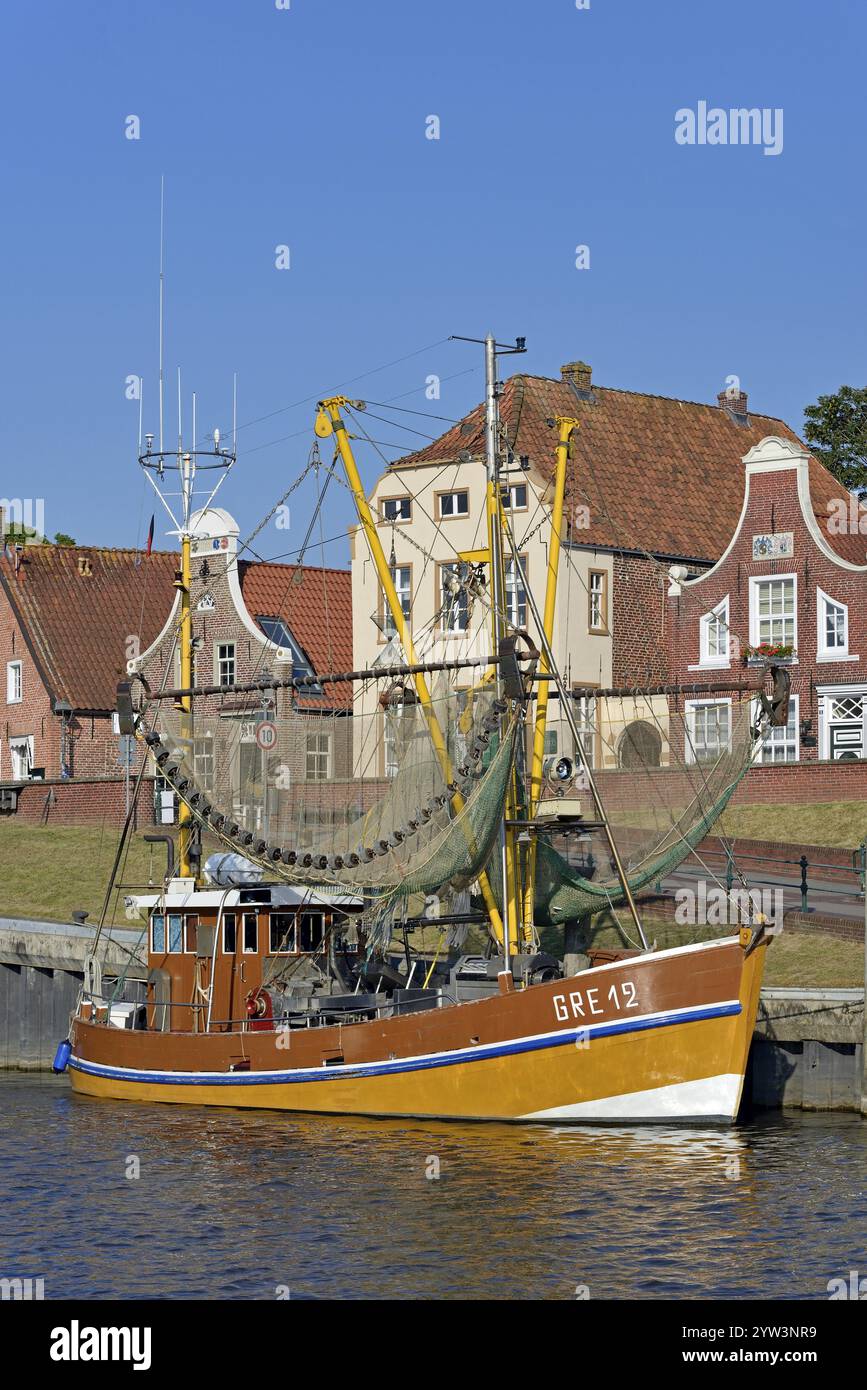 Crab cutter in the harbour in front of historic buildings, blue sky ...