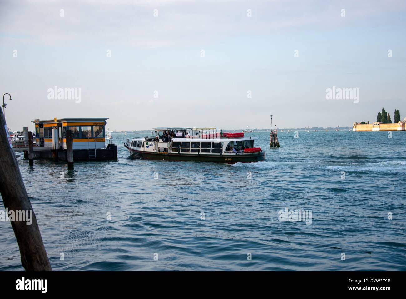A typical vaporetto ferry boat approaching the Ospedale ferry station ...