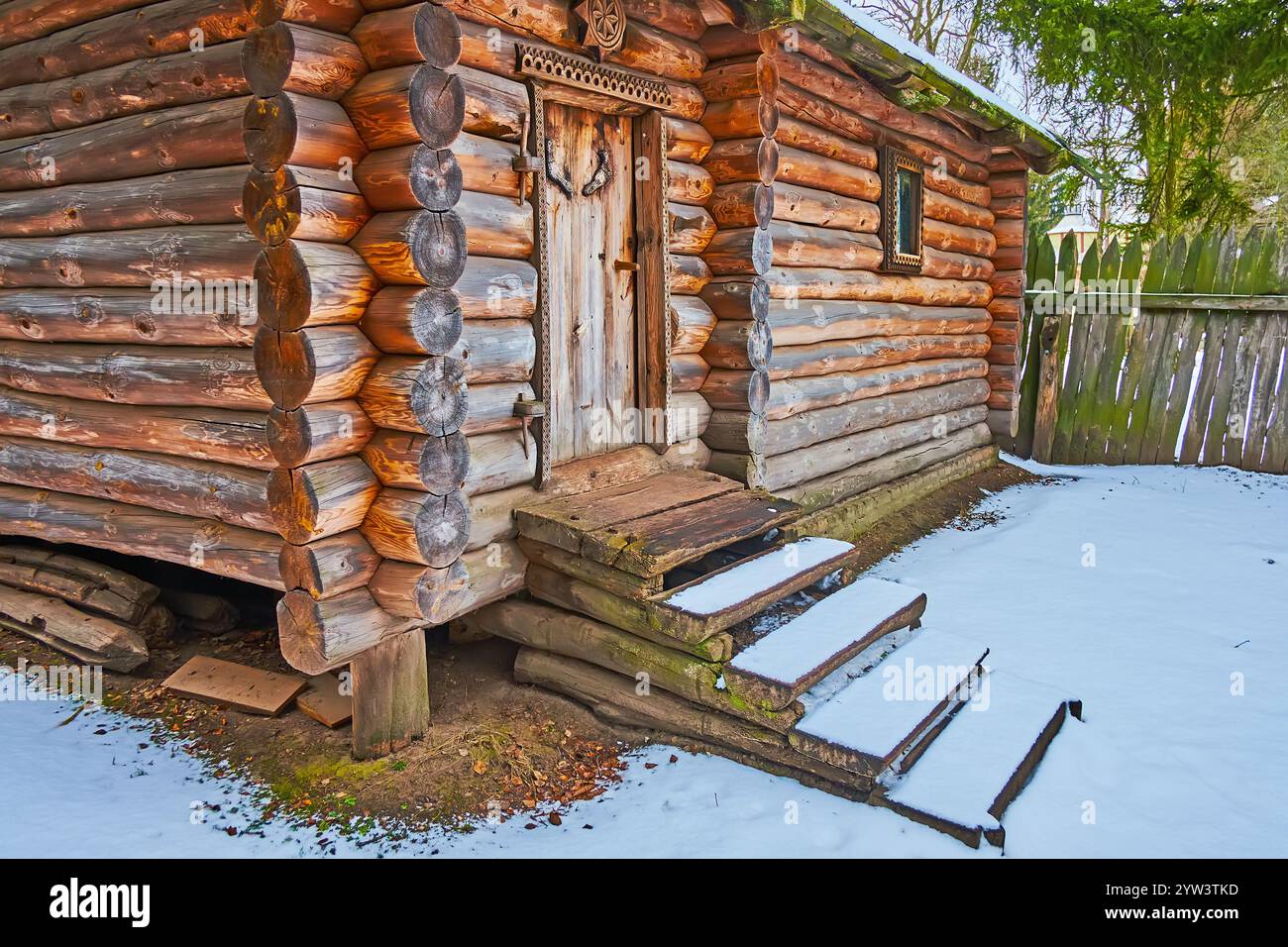 The snowy yard of the old Slavic estate with a facade of the living ...