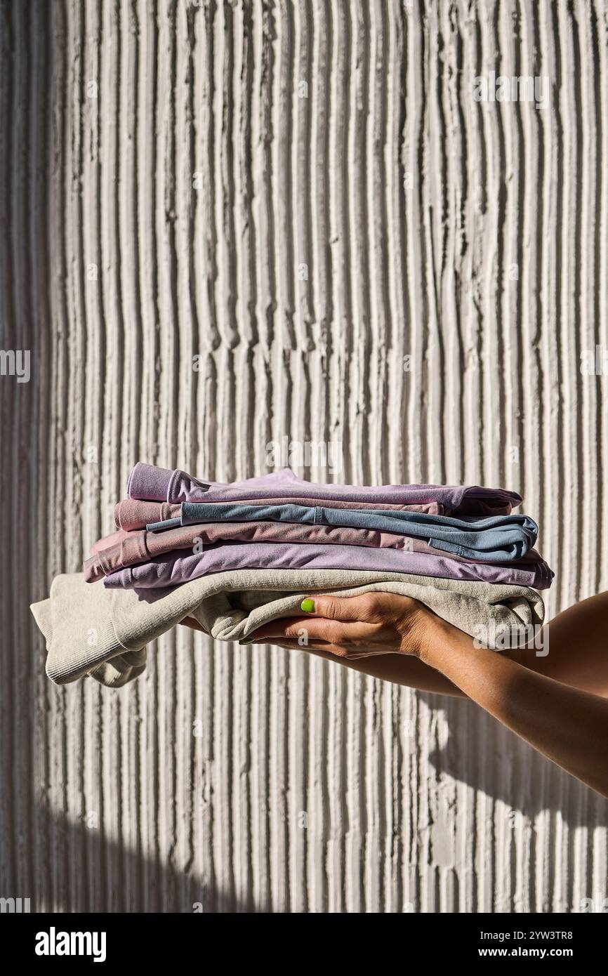 Hands Holding a Stack of Folded Clothes Stock Photo - Alamy
