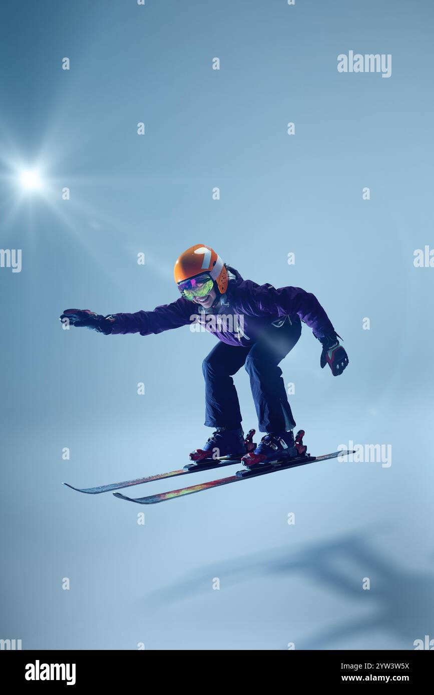 Skier leans into jump, her posture dynamic and expressive. Light blue ...