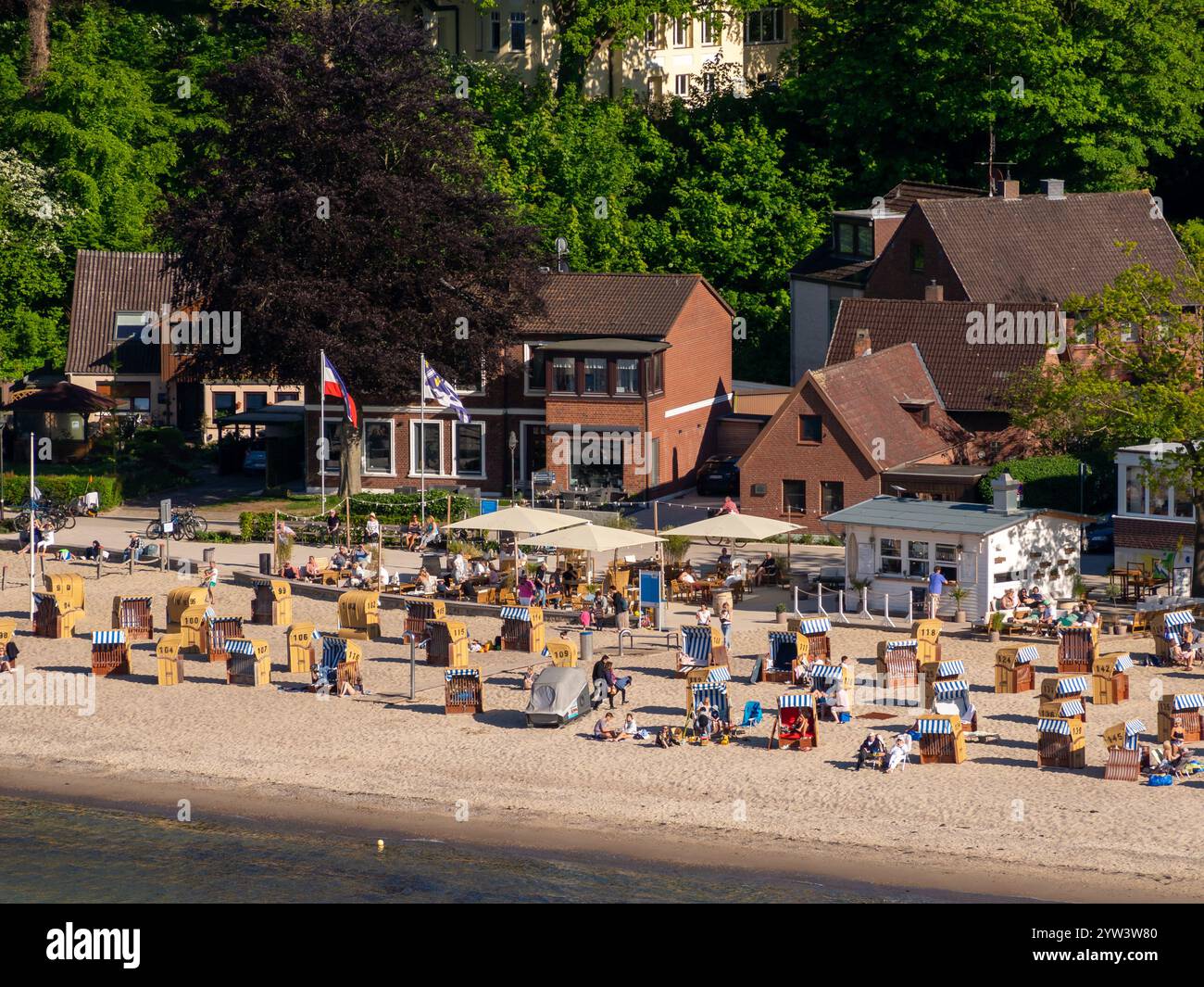 High shot of people sunbathing sat in beach chairs on a Northern German ...