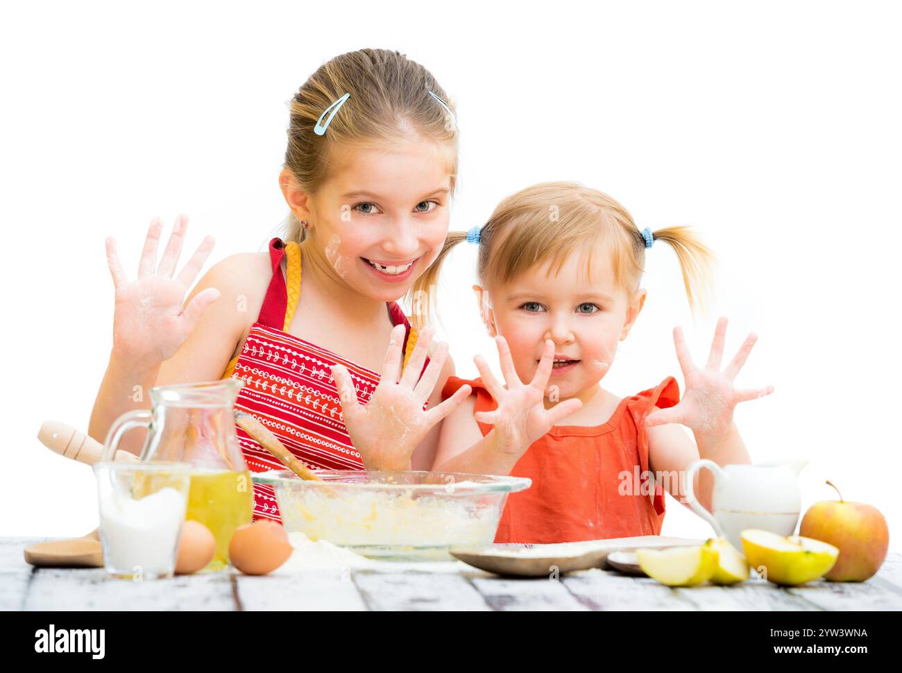 cute little sisters baking on kitchen and shows hands, on a white ...