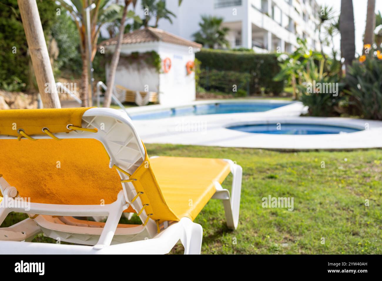 A bright yellow sun lounger or sun bed on the grass with a small ...