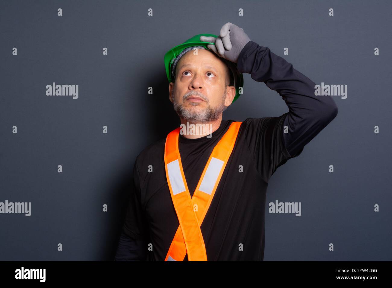 Photo of a civil worker wearing a green hard hat and reflective vest ...