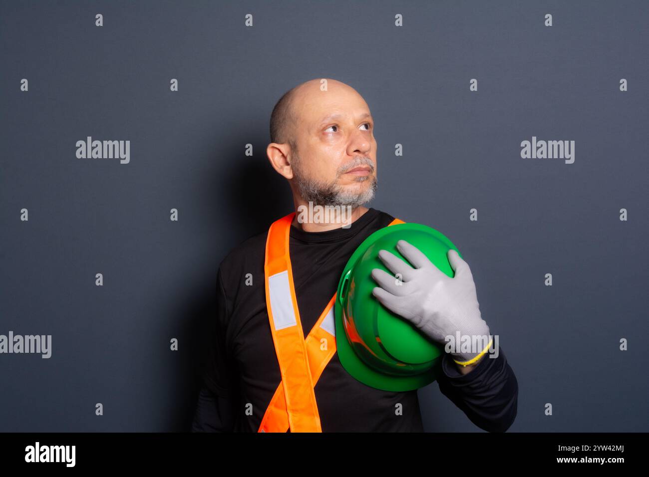Photo of a civil worker in gloves and reflective vest holding green ...