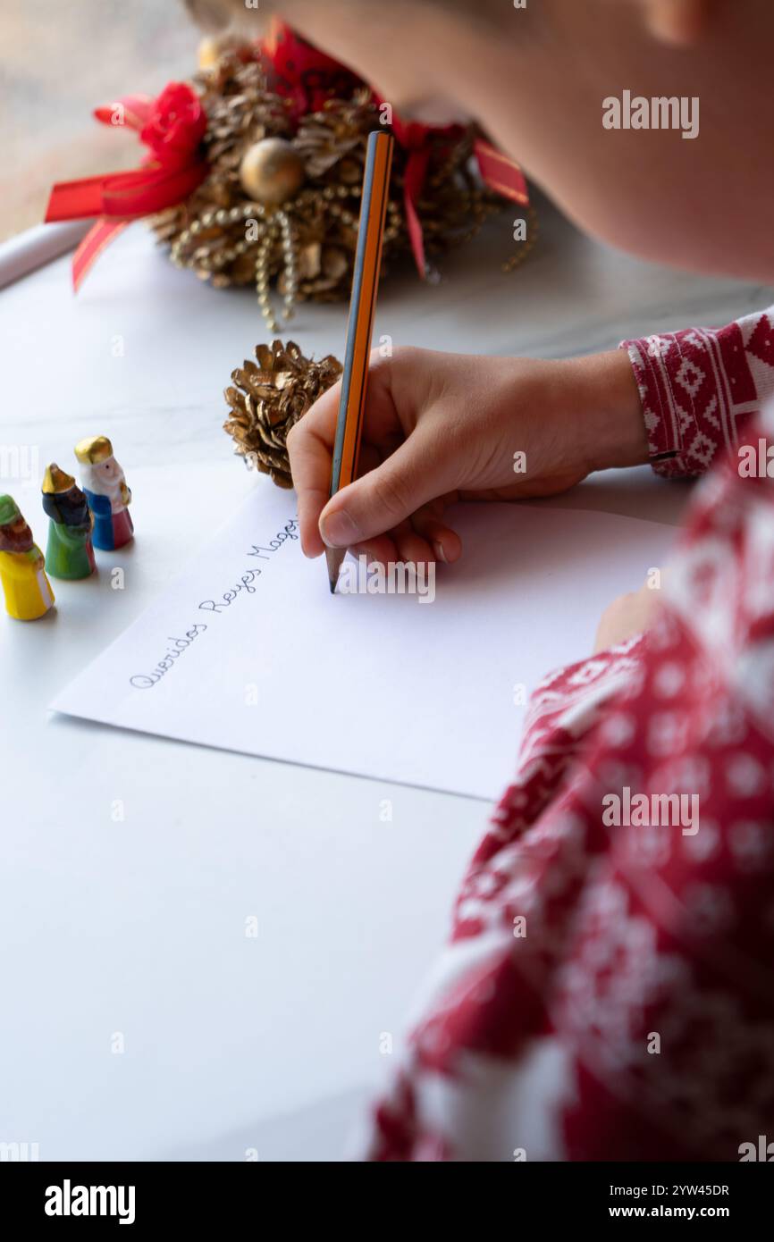 Caucasian child writing a letter to the three wise men near christmas ...