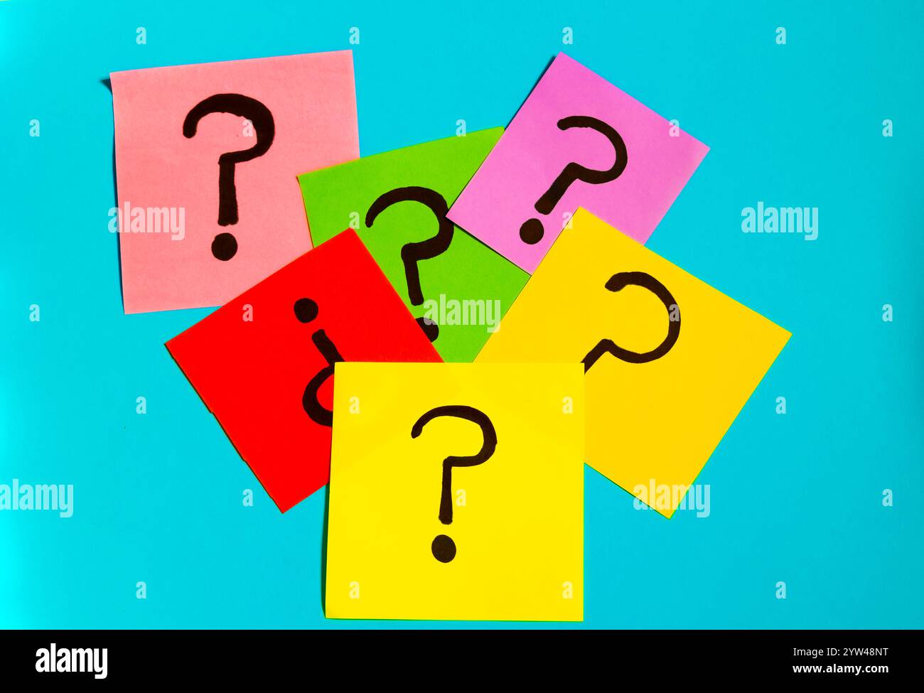 Top view of multi colored sticky papers with drawn question marks ...