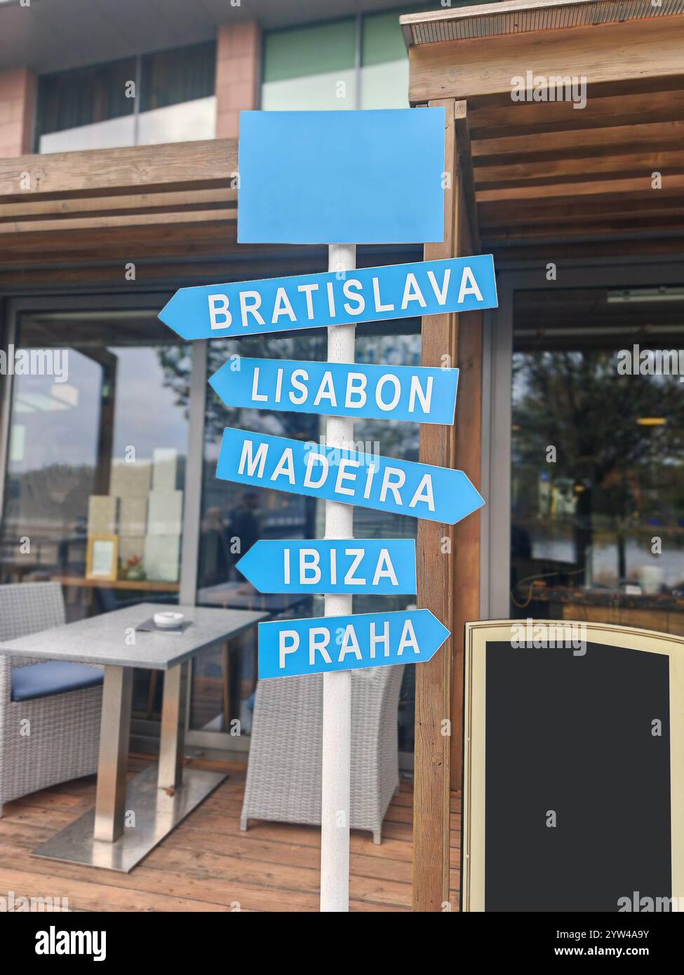 Direction signs european cities in front of restaurant in shopping ...