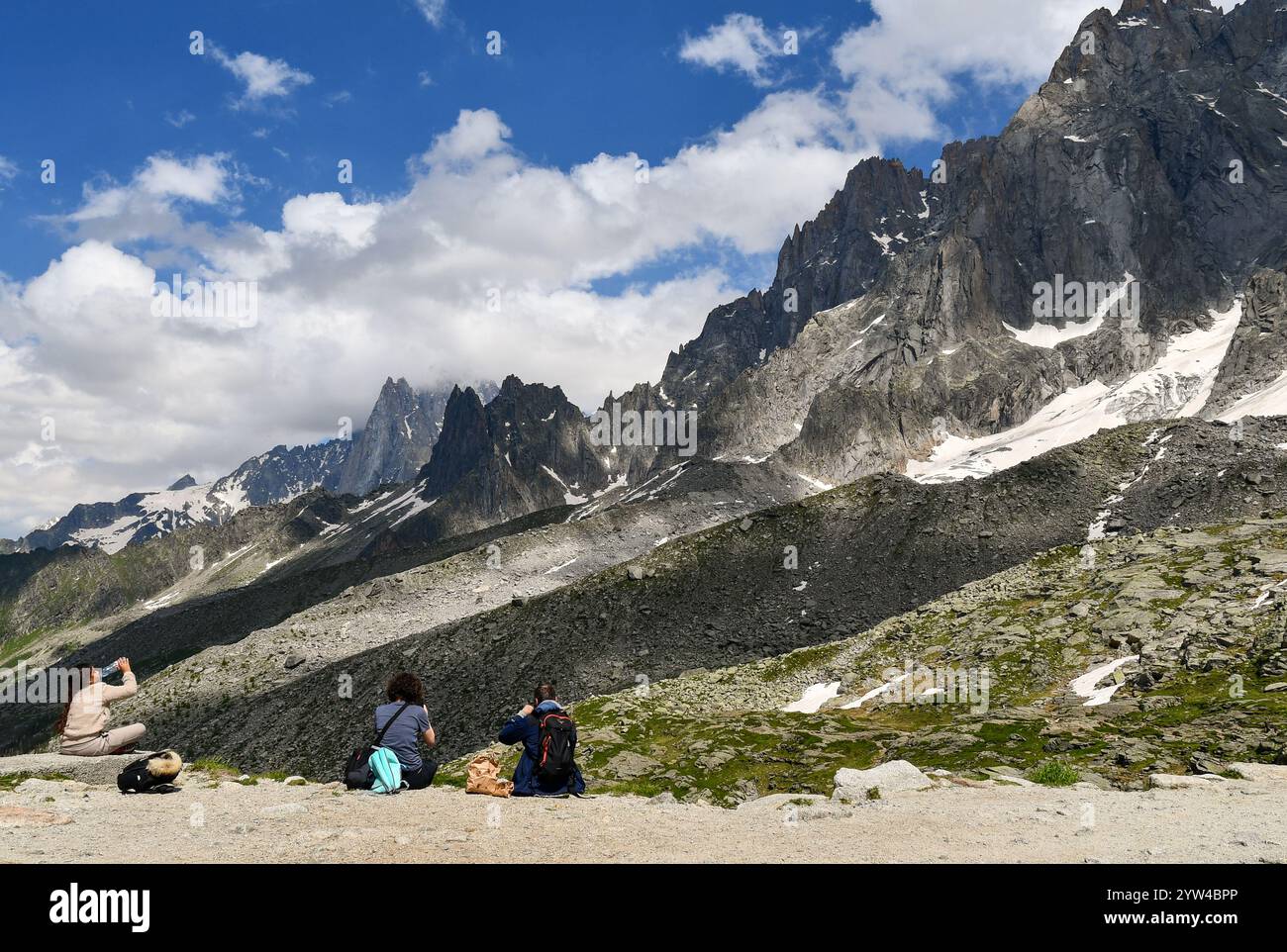 Three hikers at the Plan de l'Aiguille (2317 m), resting and admiring ...