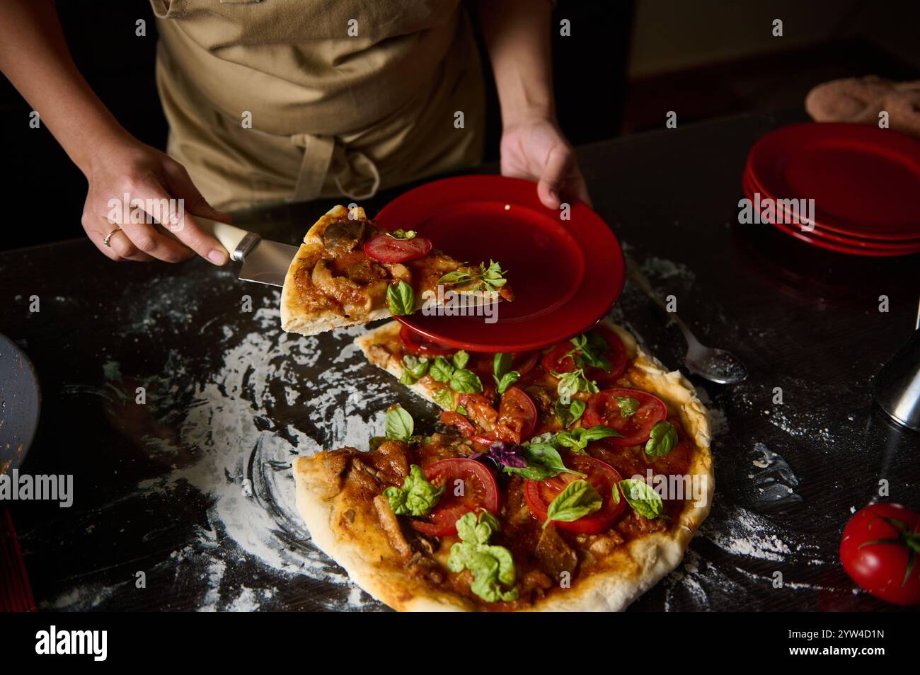 A close-up of a person serving a slice of freshly made pizza with ...